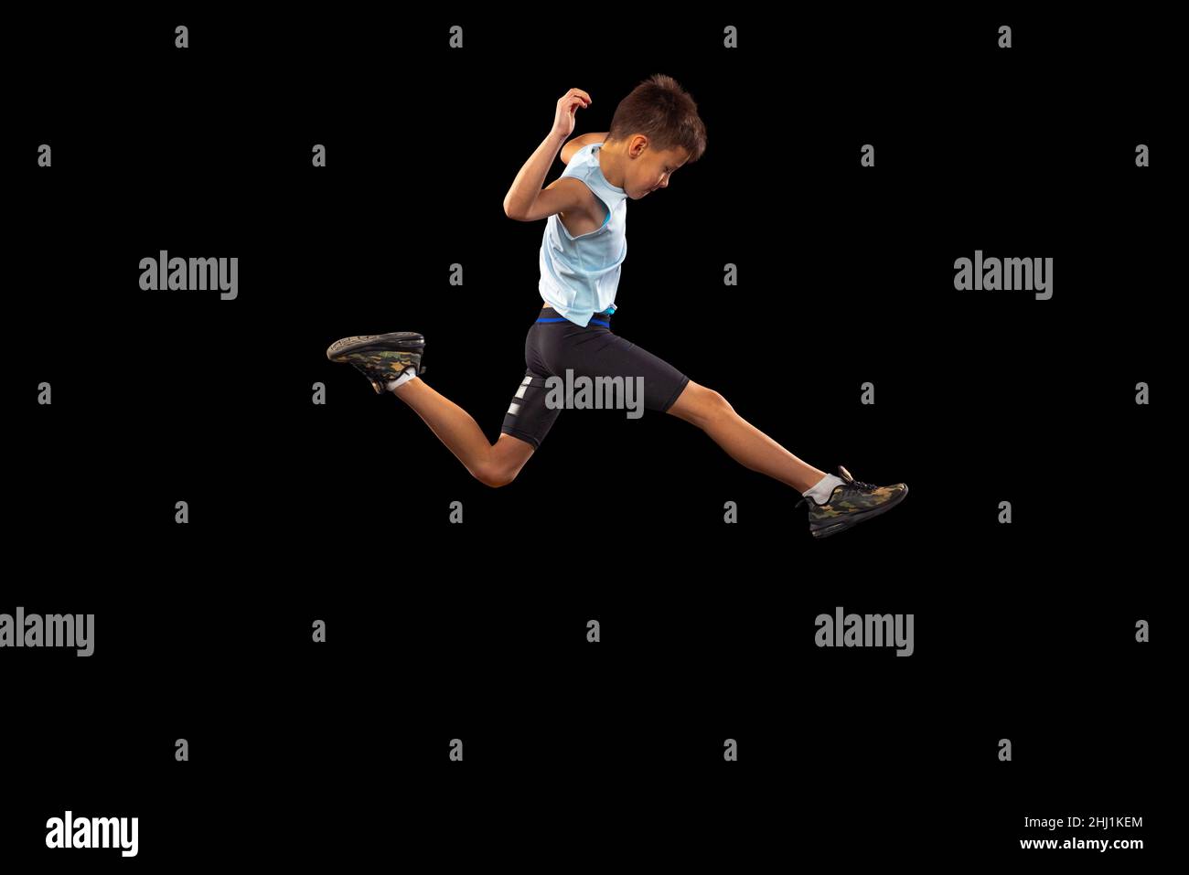 Ful-length side view portrait of young boy, running athlete training ...