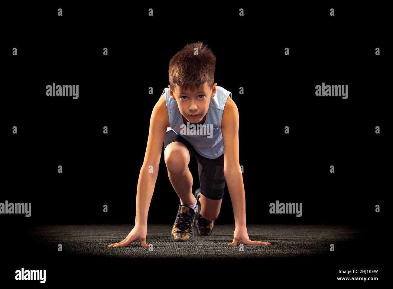 Full-length portrait of little boy, running athlete preparing to run ...