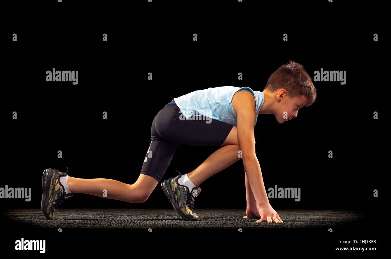Full-length portrait of little boy, running athlete preparing to run ...