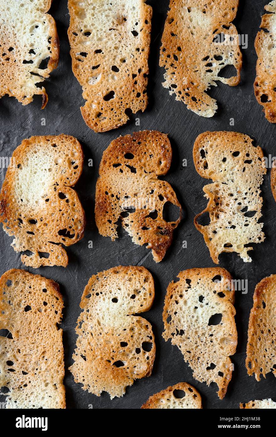 Pattern of home-cooked snacks of salted bread chips, on a black ...