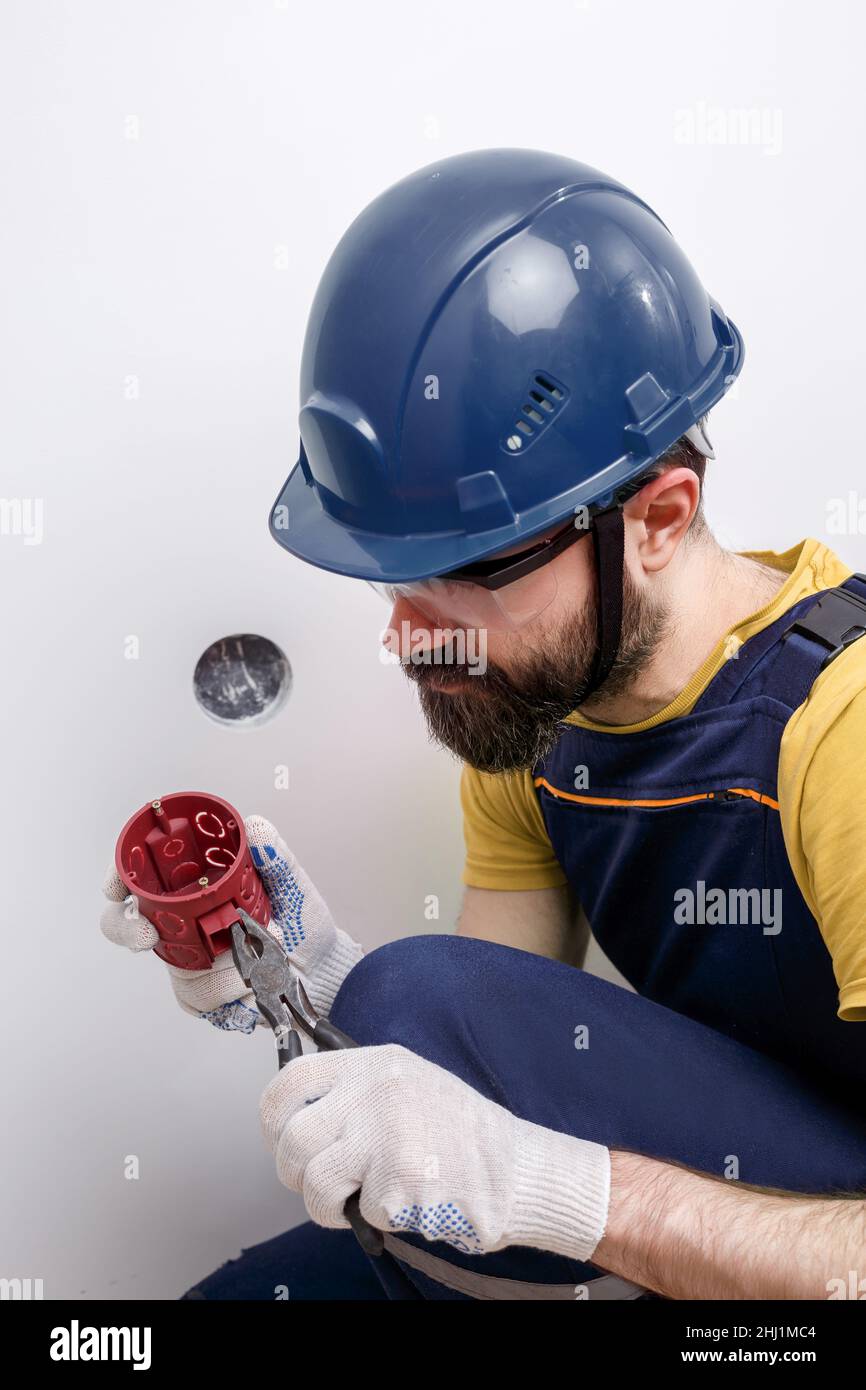electrician in helmet installs sockets Stock Photo - Alamy