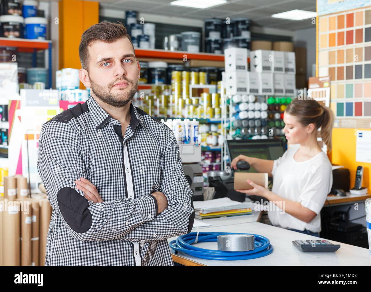 Male with tools and woman seller at cash desk Stock Photo - Alamy
