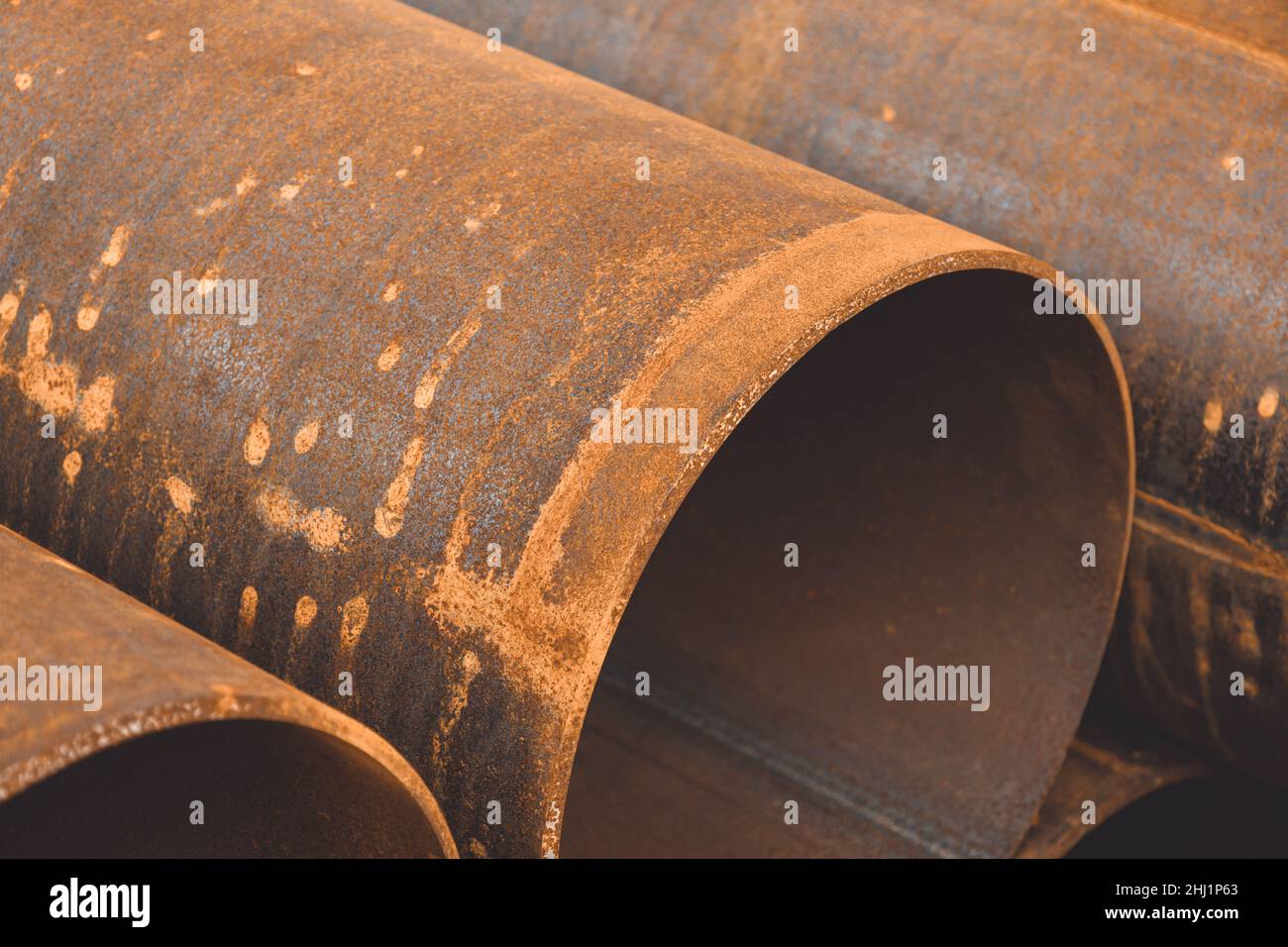 Stack of big rusty steel pipe at a construction site. Installation of ...