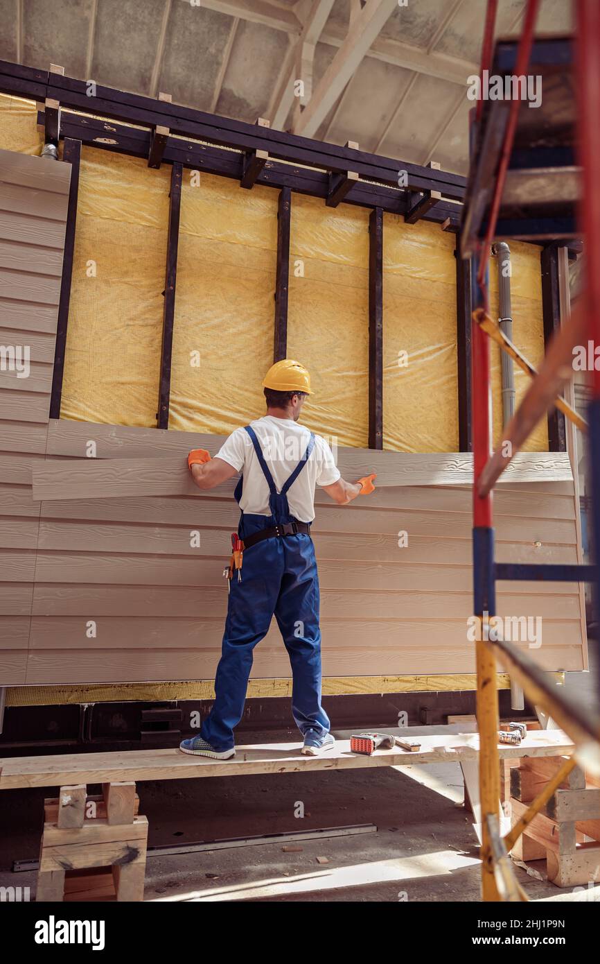 Male builder building house at construction site Stock Photo - Alamy