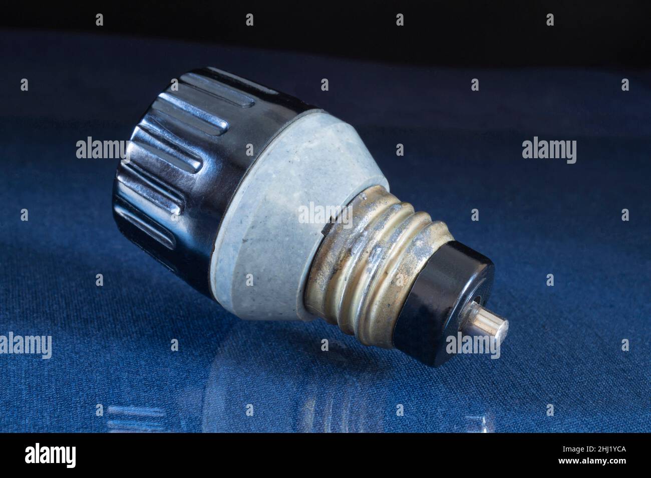 An electric fuse on a blue table with a reflection. Plastic object on a ...