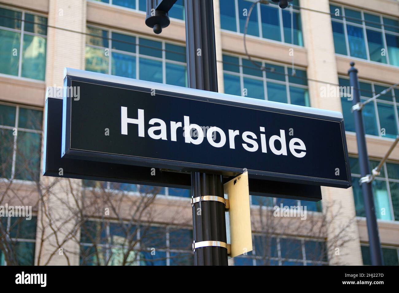 Harborside black and white sign on the station on the light rail path ...
