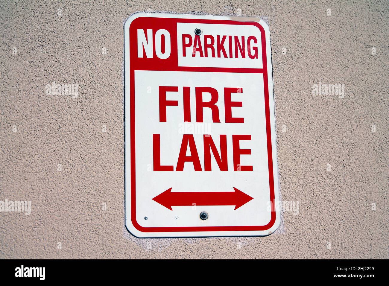 No parking, fire lane white and red sign hanged on a concrete wall ...