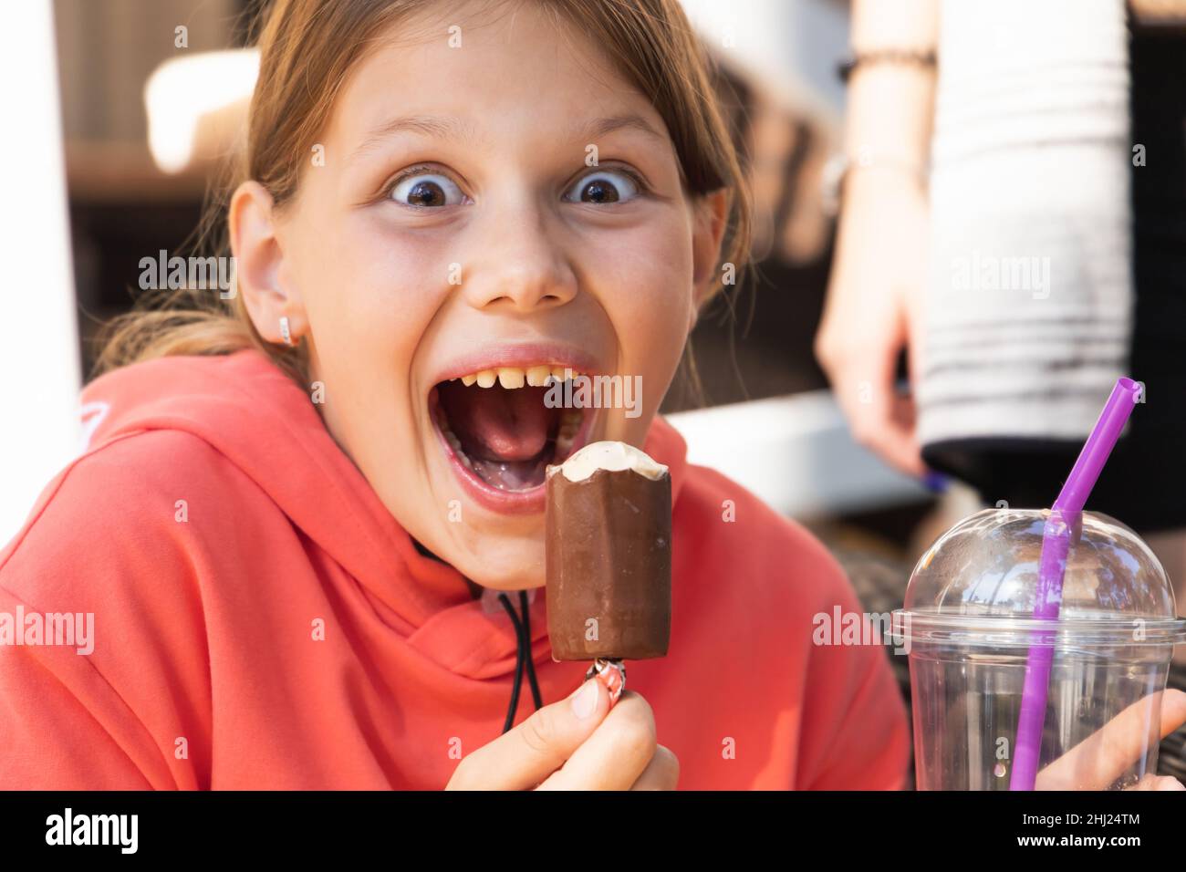 Happy little girl have fun with an ice cream, close-up outdoor portrait ...
