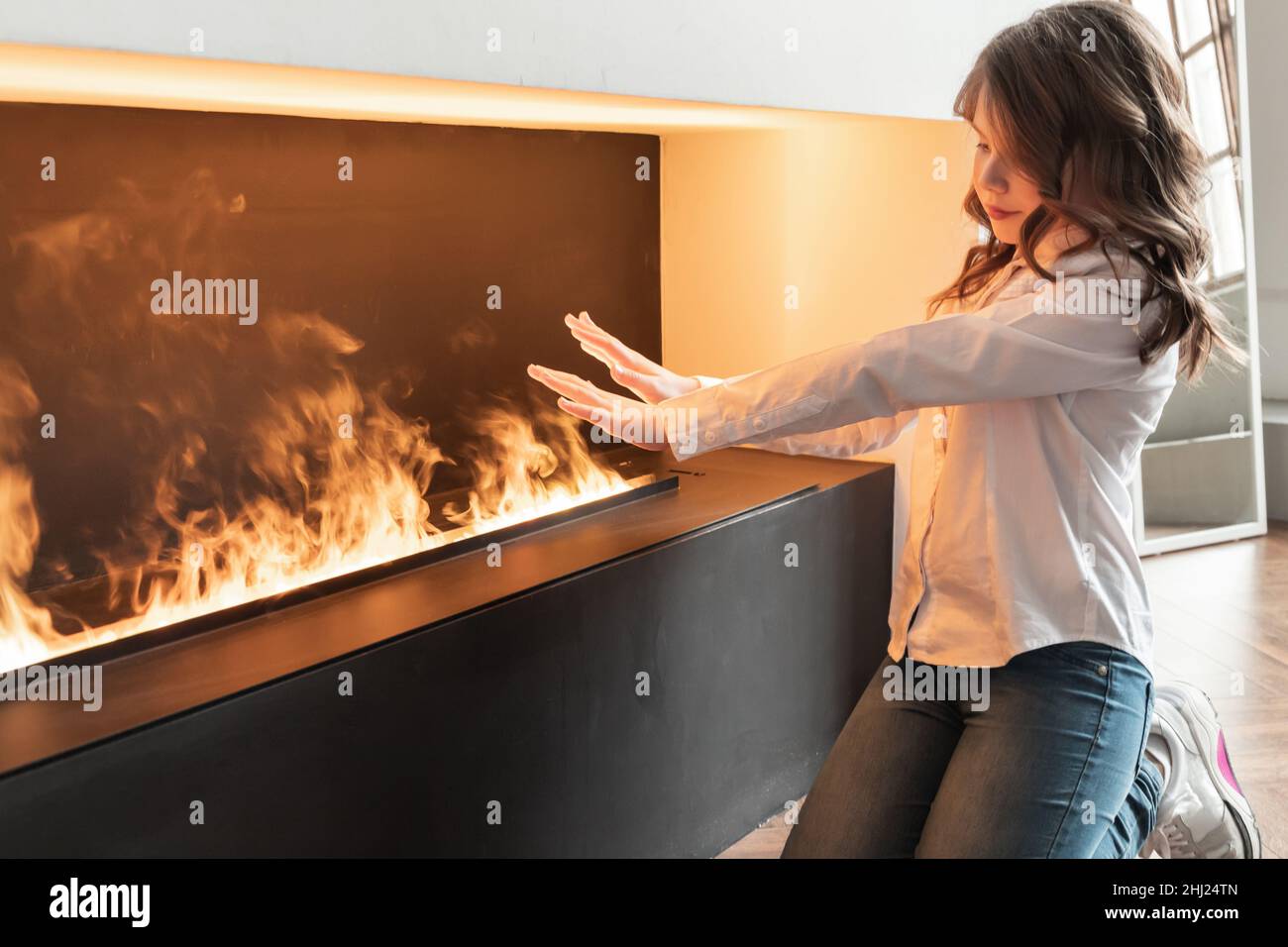 Little girl warming her hands at the fireplace Stock Photo - Alamy