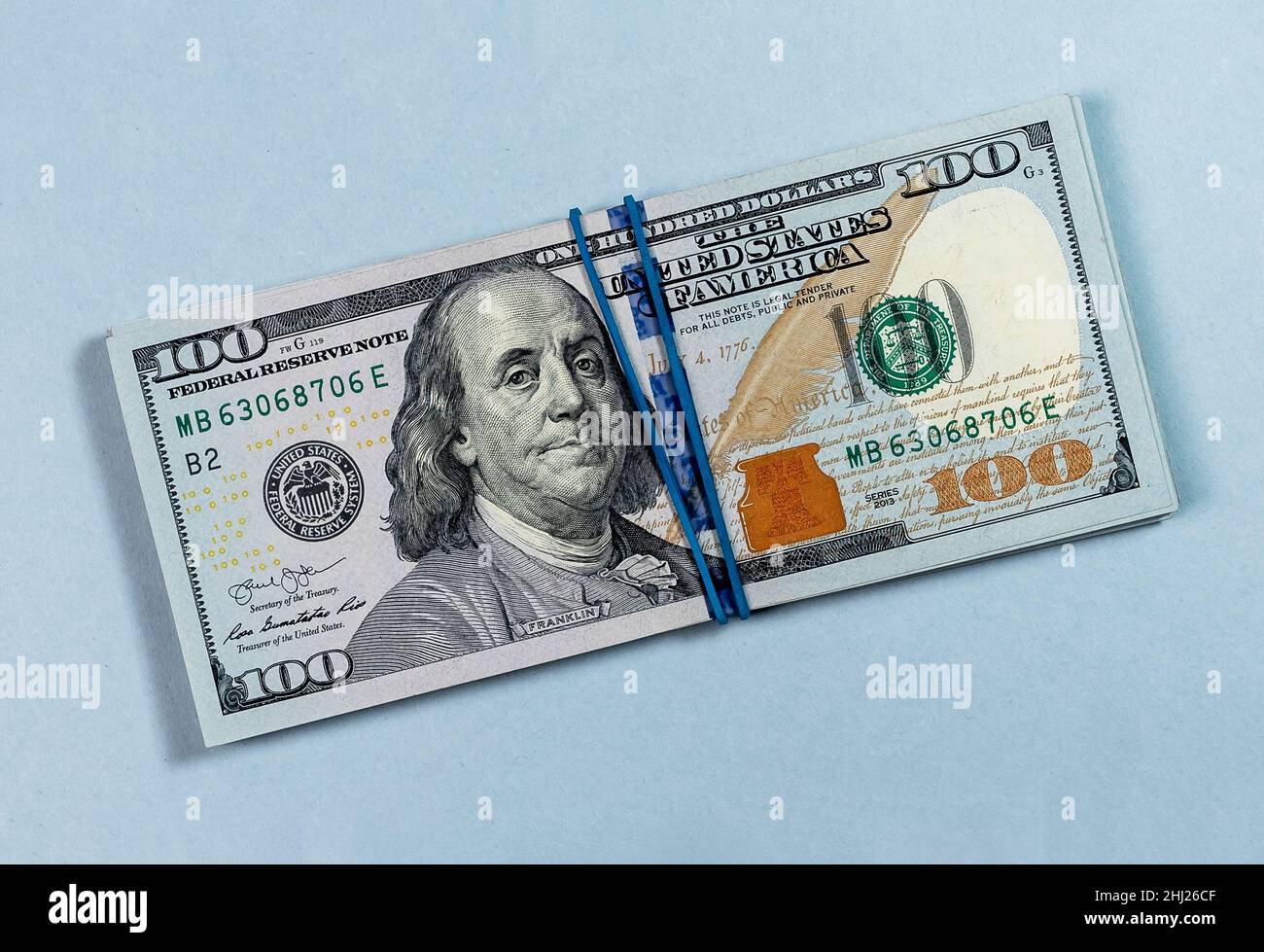 Dollar cash, 100 hundred bills stack on blue Stock Photo - Alamy
