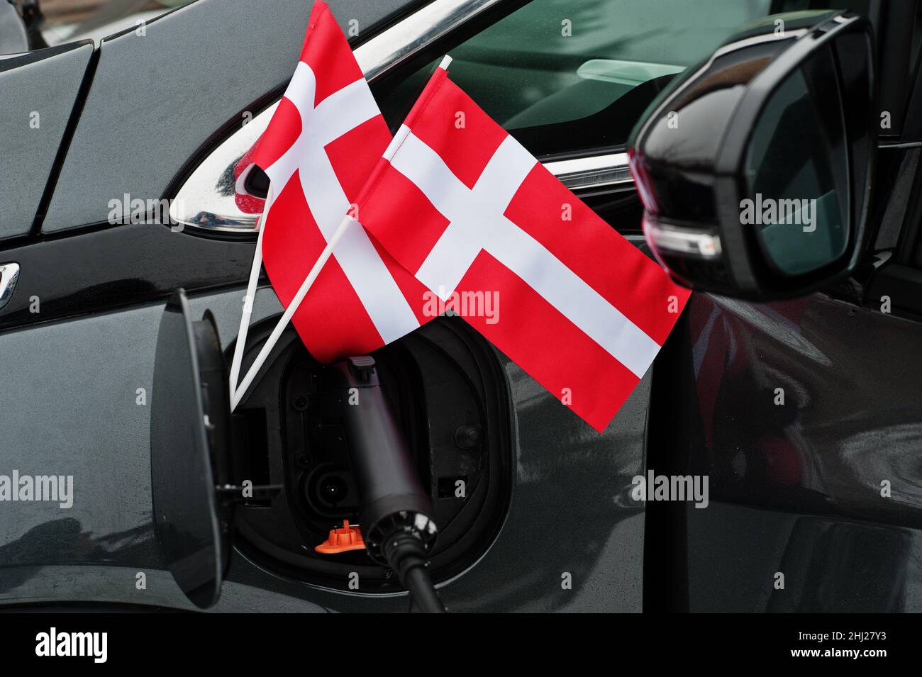 Denmark flag ecological car concept. Plugging a power supplier ...
