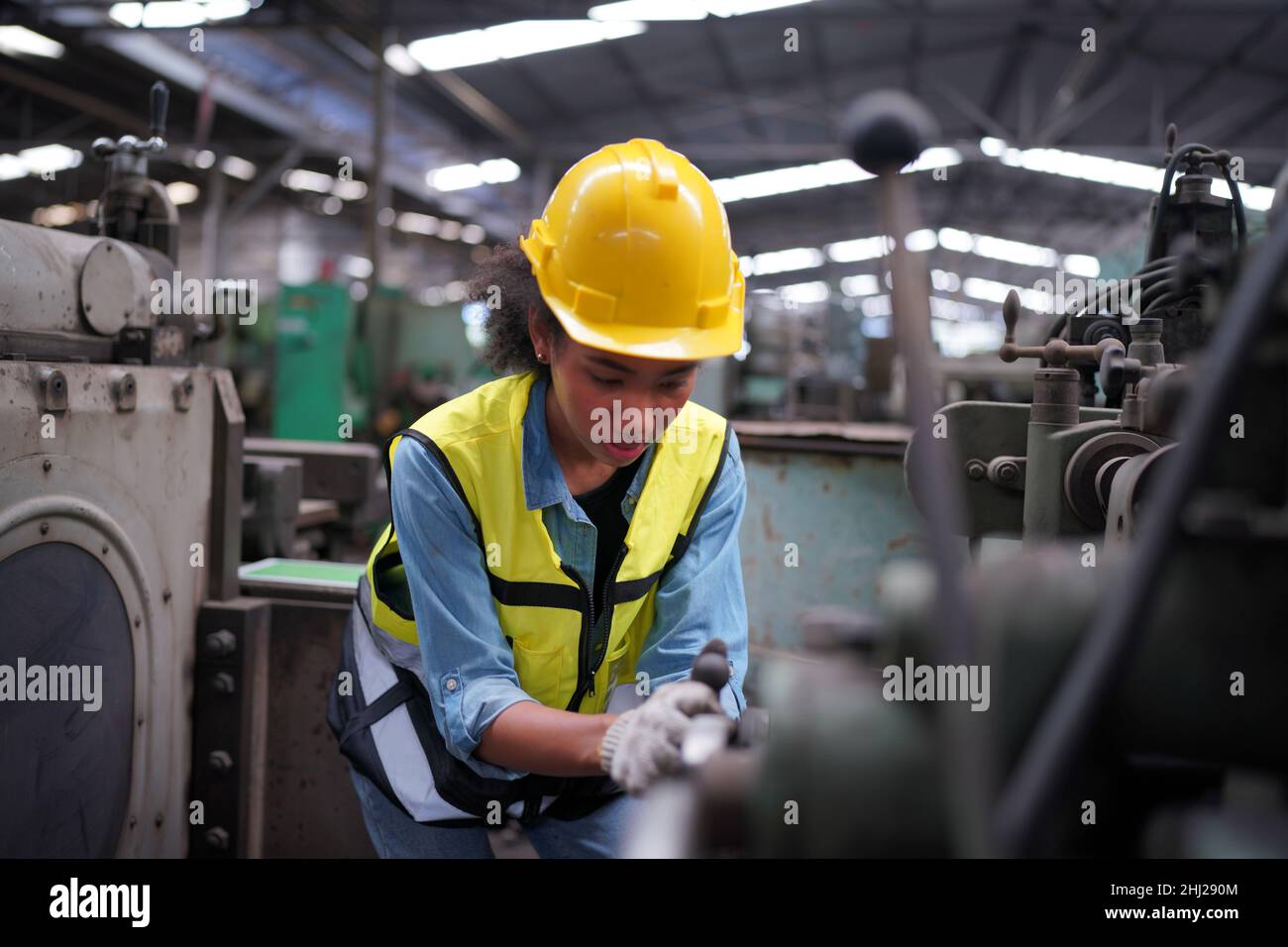 Female apprentice in metal working factory, Portrait of working female ...