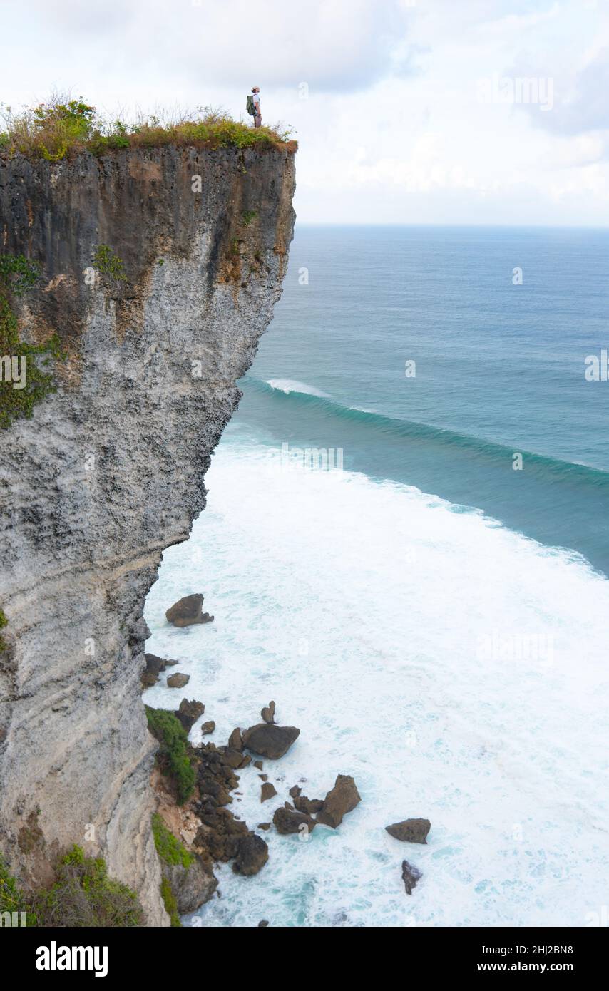 a man standing on a cliff watching the ocean Stock Photo - Alamy