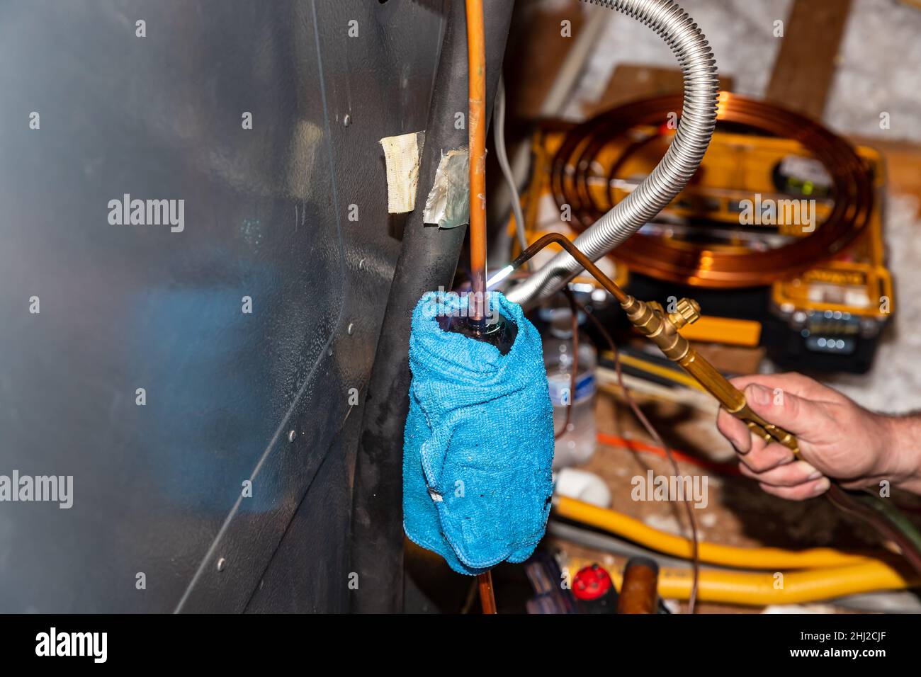 Air Conditioner Technician using a brazing torch to repair equipment ...