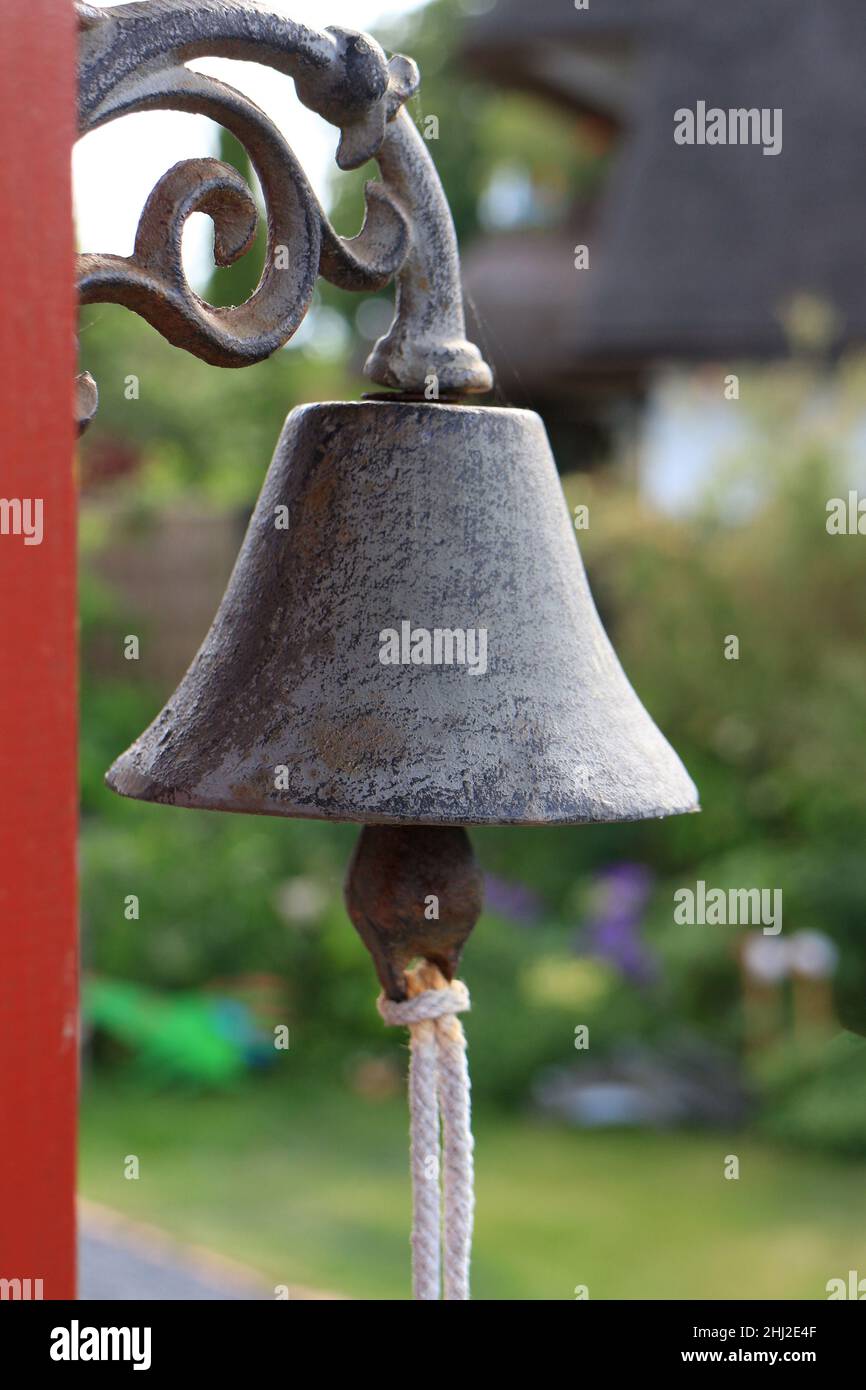 Old weathered traditional cast iron bell hanging outside a building ...