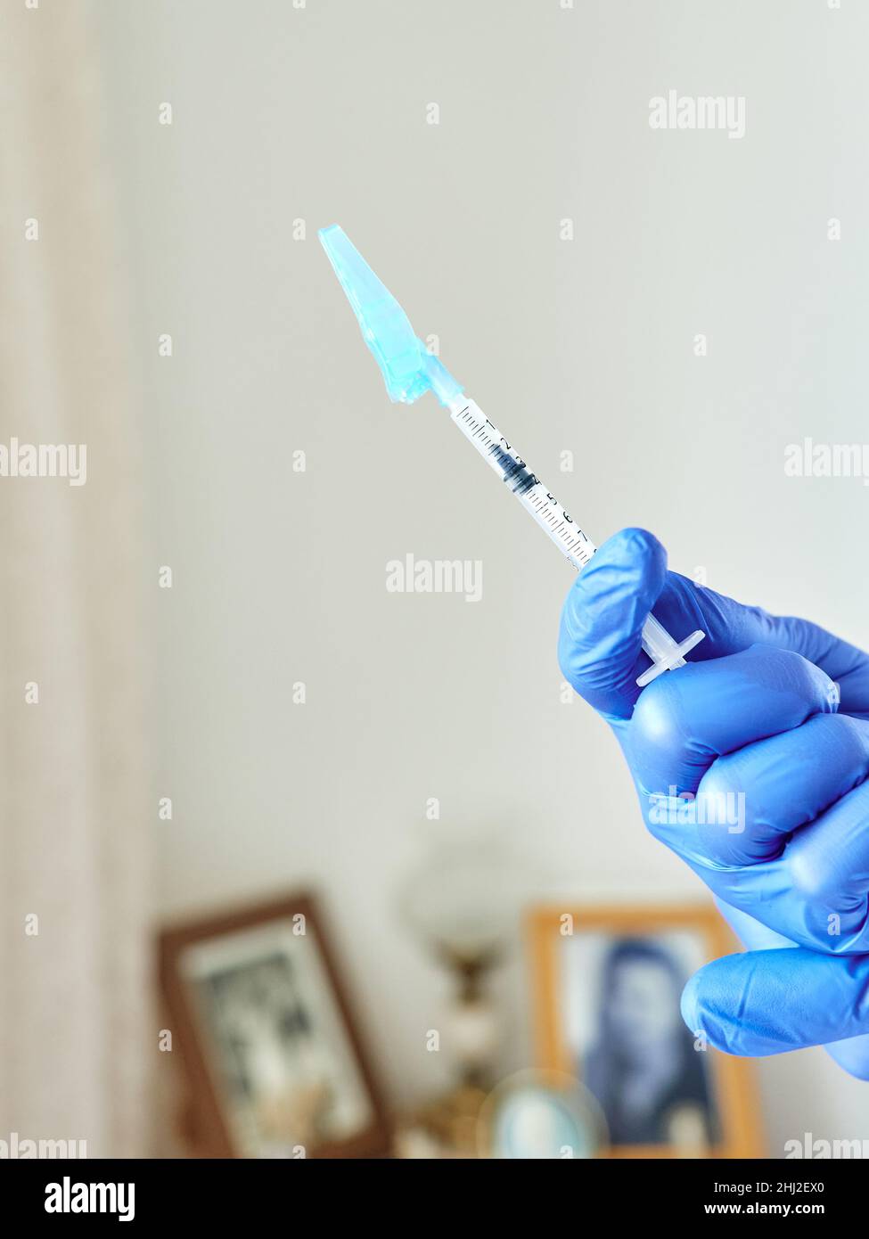 Doctor's hand holding an original syringe with blue adapter with covid ...