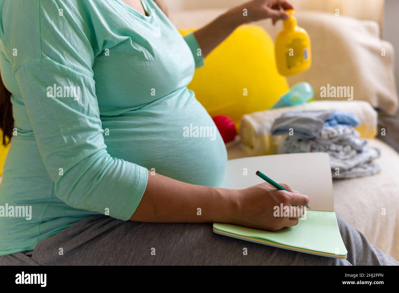 Cute Pregnant Woman writing packing list for maternity hospital With ...