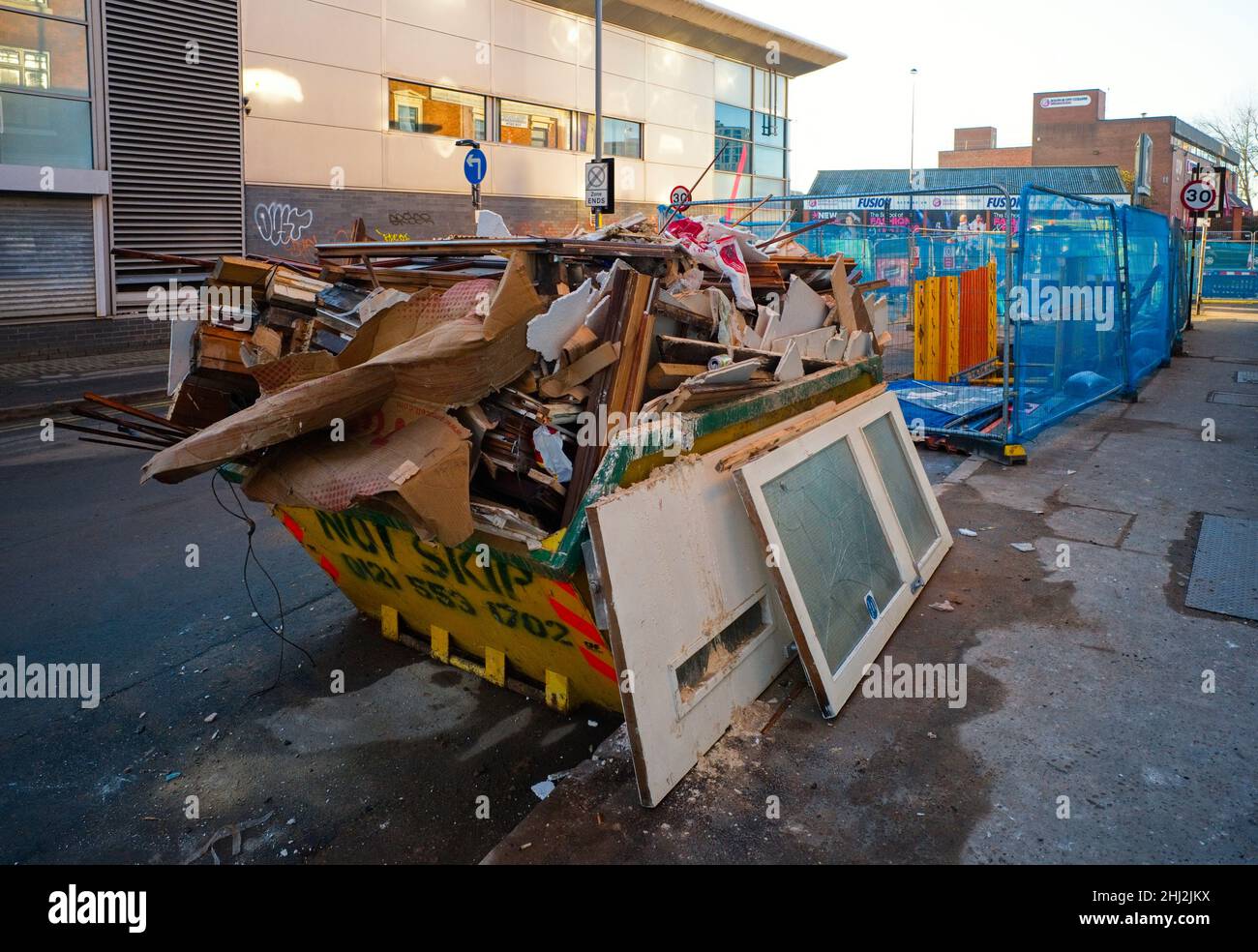 Skip full of builders rubbish on street in Digbeth, Birmingham Stock ...