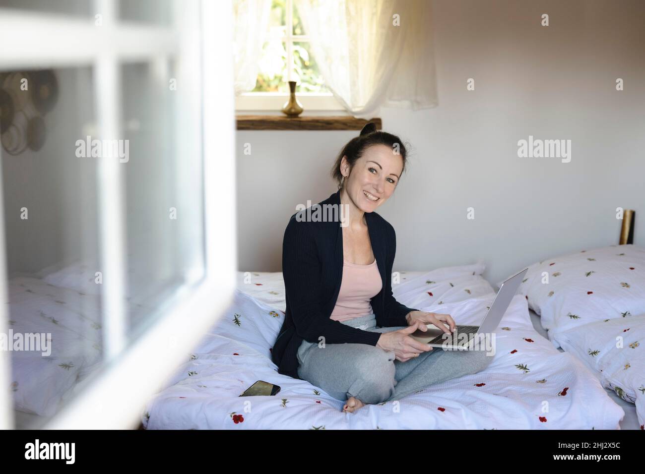 Woman sitting comfortably on bed hi-res stock photography and images ...