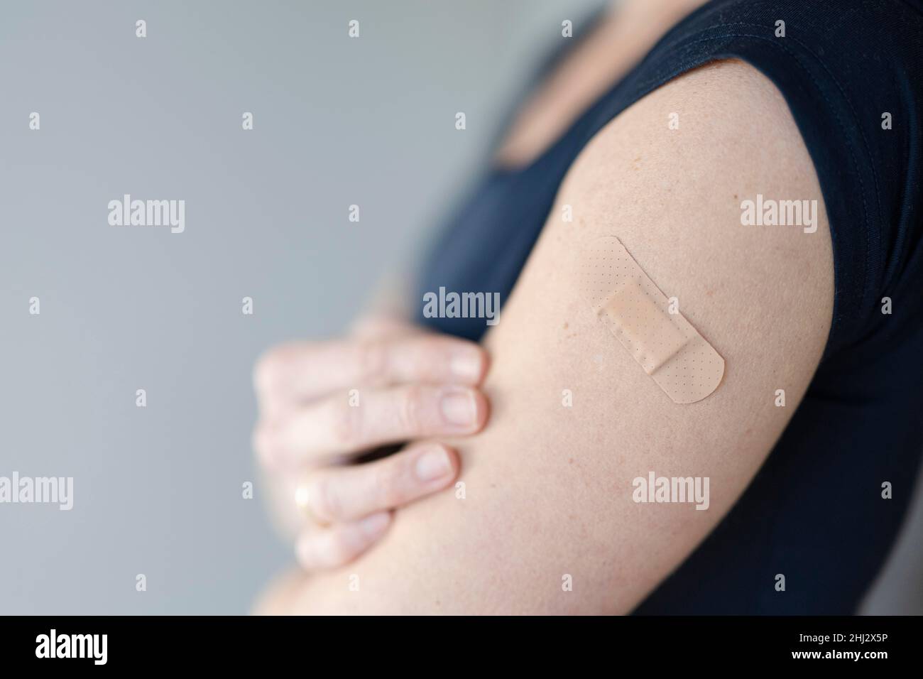 Arm of a woman with a plaster on her upper arm after vaccination Stock ...
