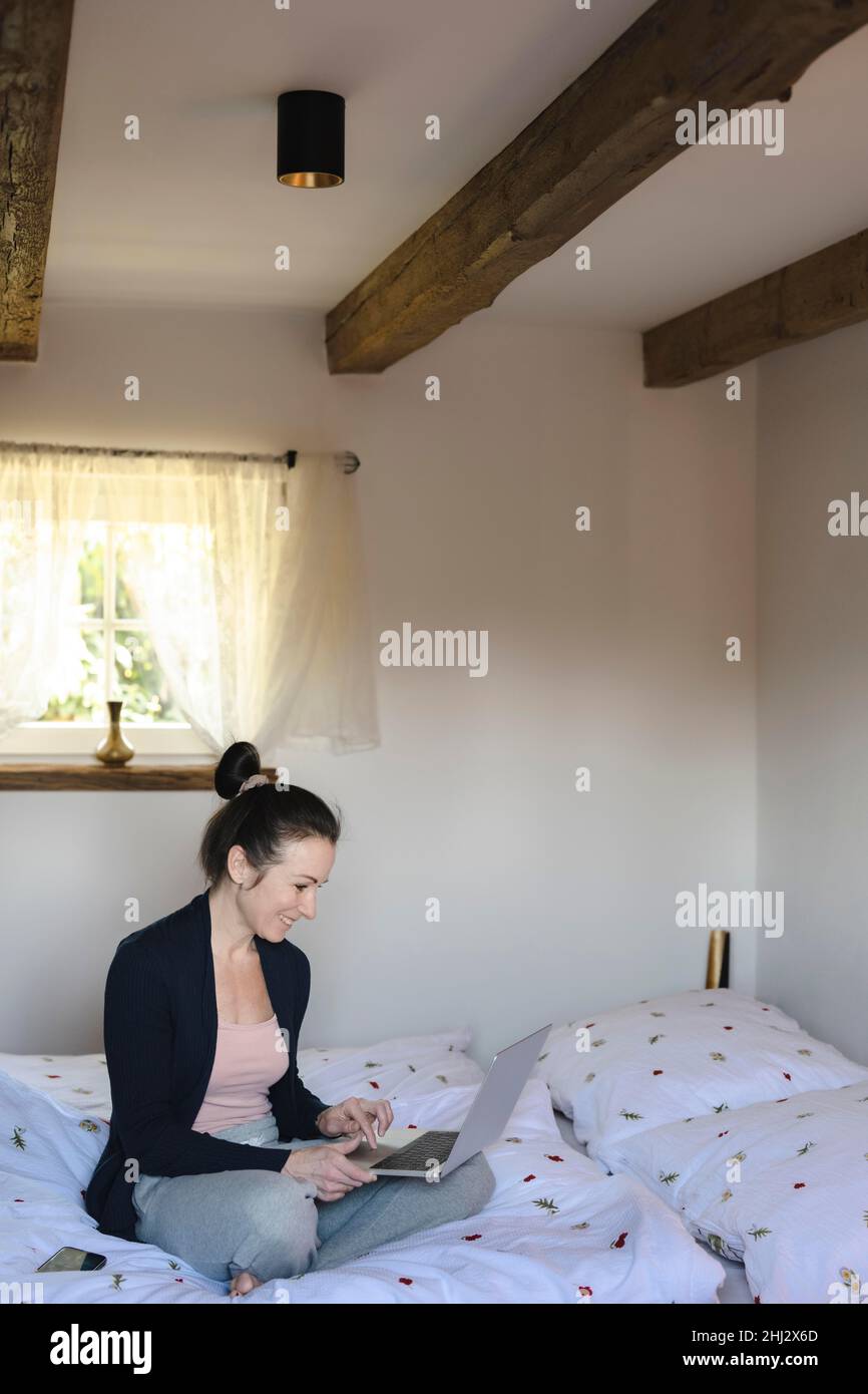 Woman sitting comfortably on bed hi-res stock photography and images ...