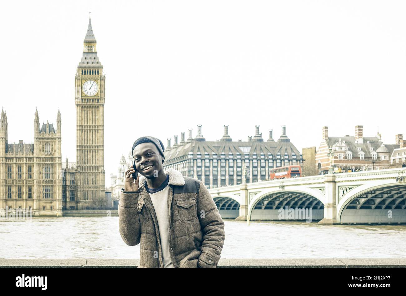 African american young man using mobile smart phone at Thames riverbank ...
