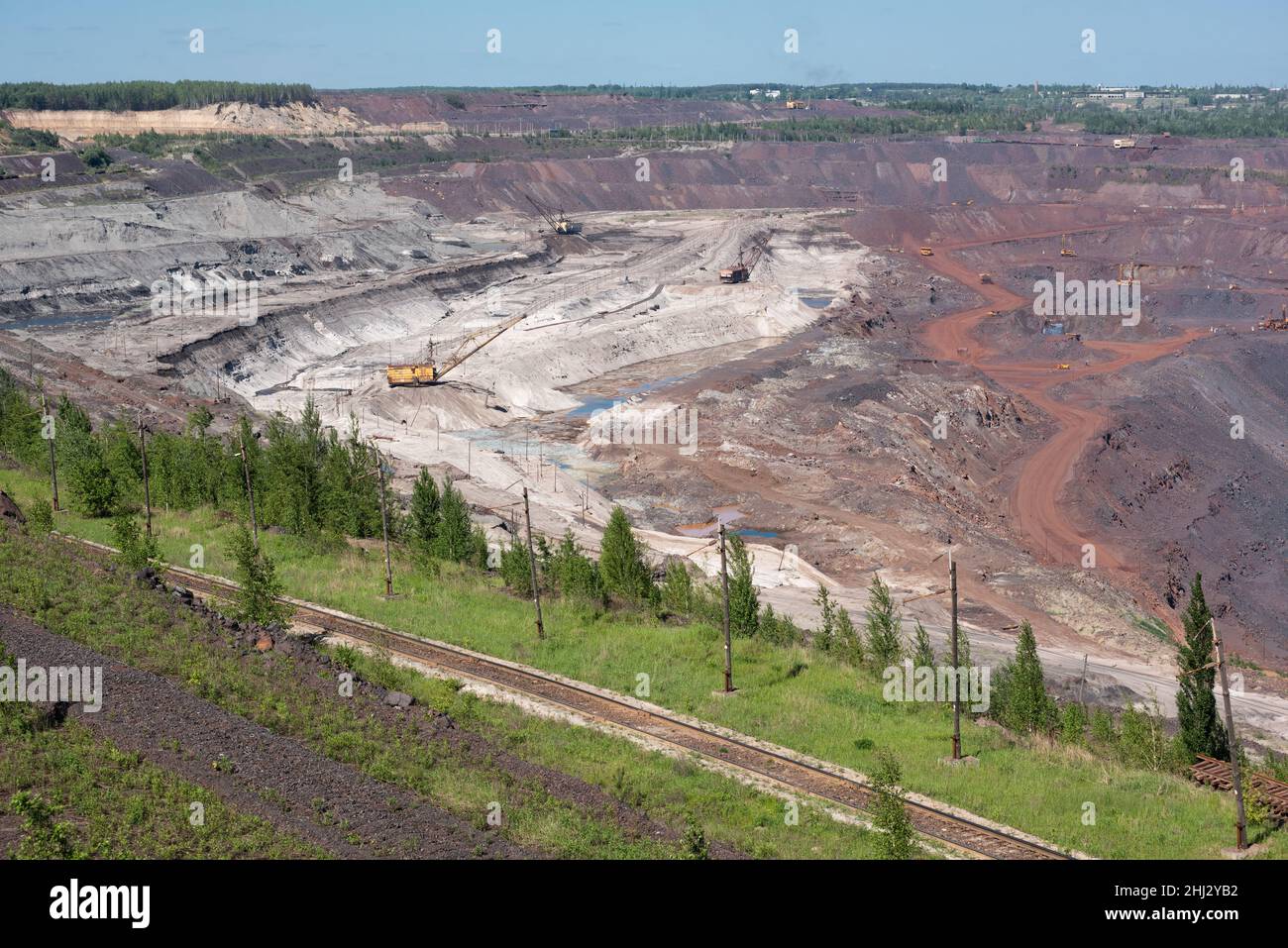 Open iron ore quarry with walking excavator, railway transportation ...