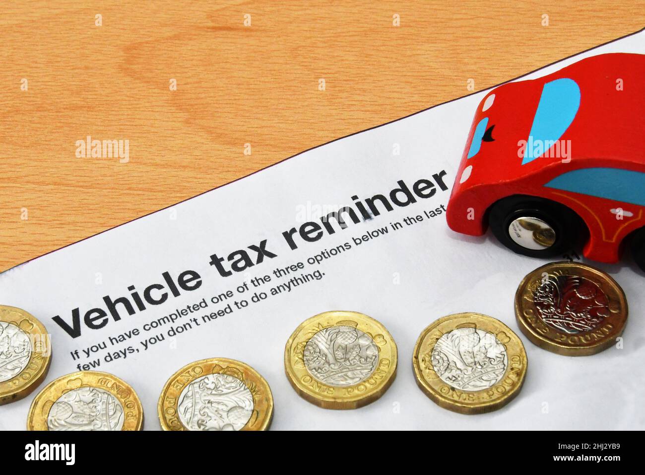 Top of a vehicle tax reminder letter with one pound coins anda model ...