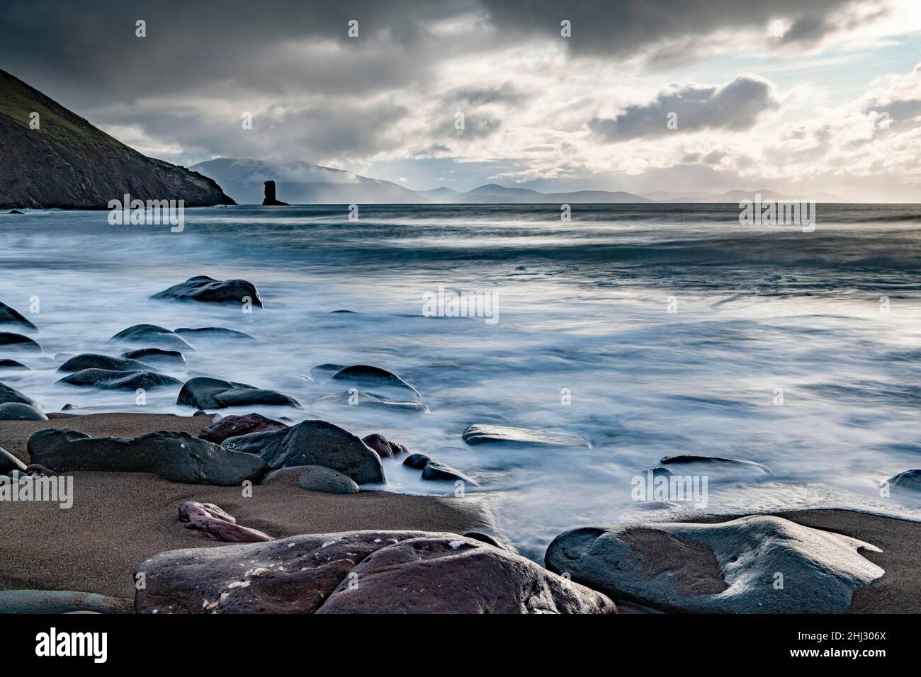 Sandy beach beach with stones on North Atlantic with rocky outcrop and ...