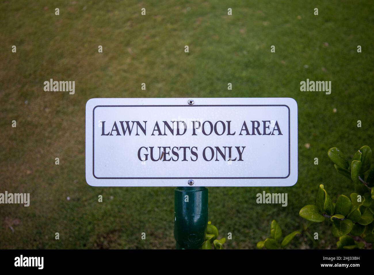 Warning sign warns tourists and visitors to stay out of lawn and pool ...