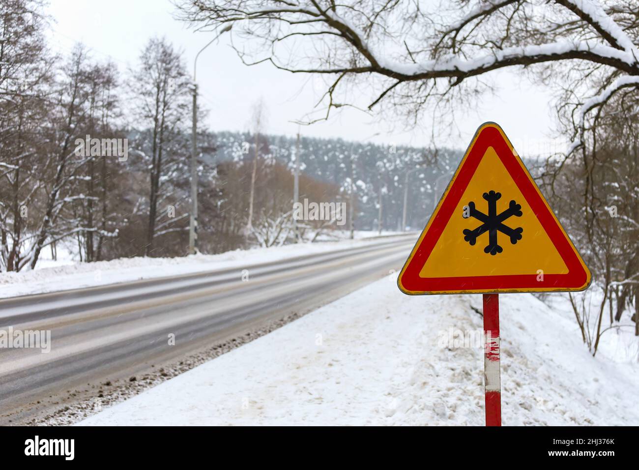 Temporary road signs on the road. Winter traffic warning sign shows ...
