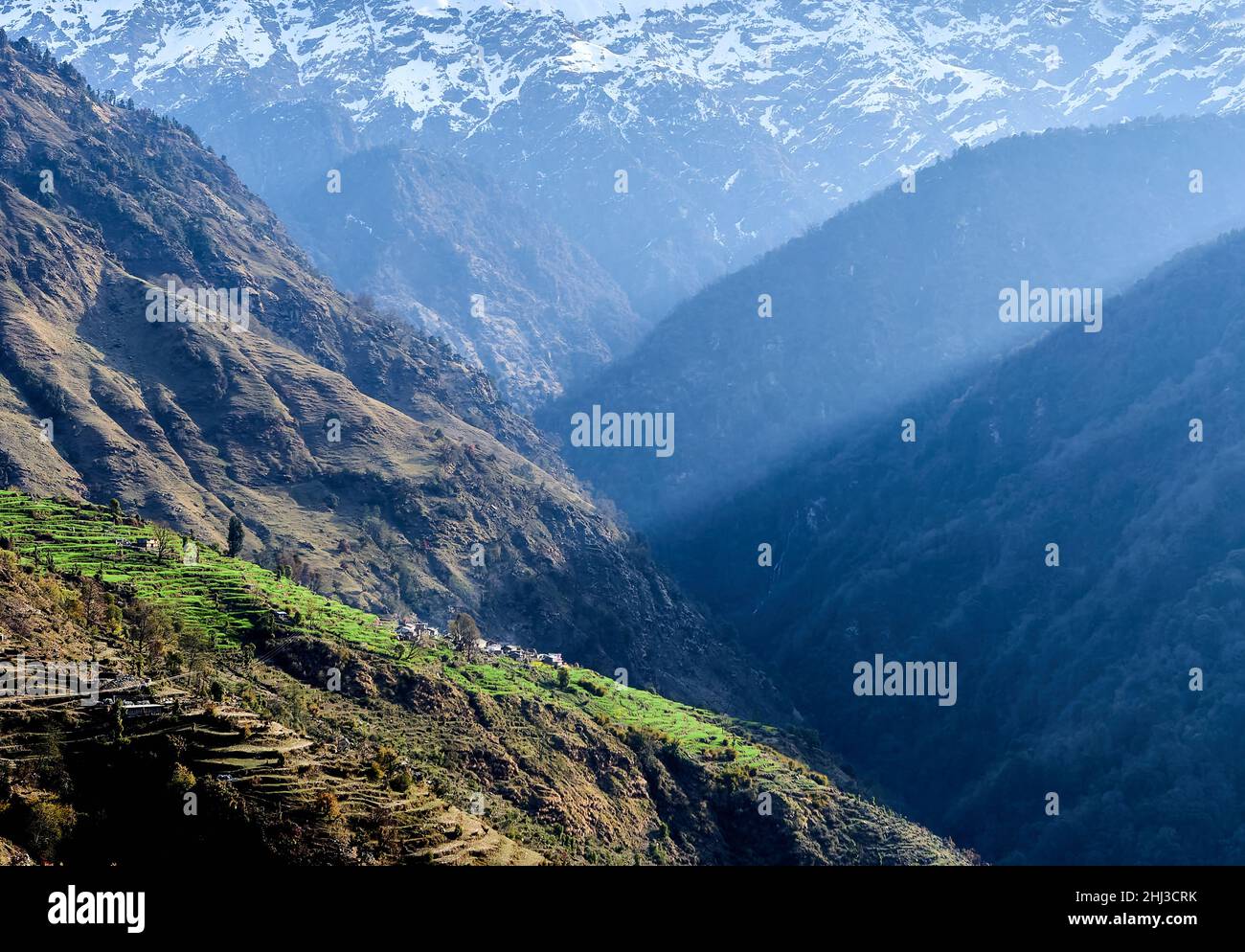 The last terraces and houses of the remote village of Jhuni dwarfed by ...