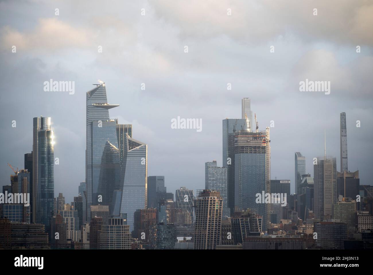 A touch of sunlight on Midtown Manhattan highrises on a gray and cloudy ...