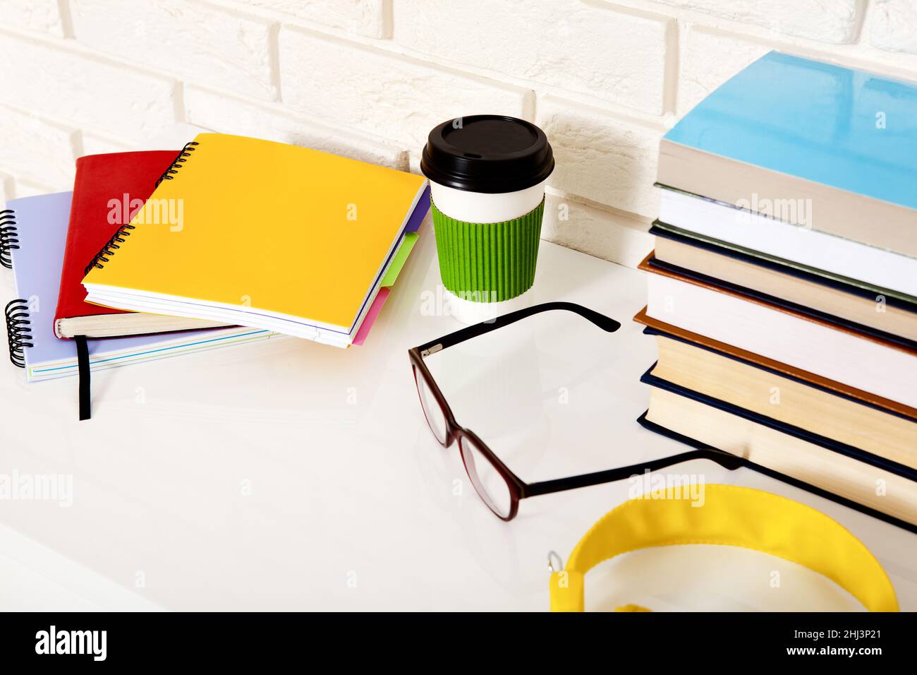 Workspace and education accessories on the table. Cup of coffee, books ...