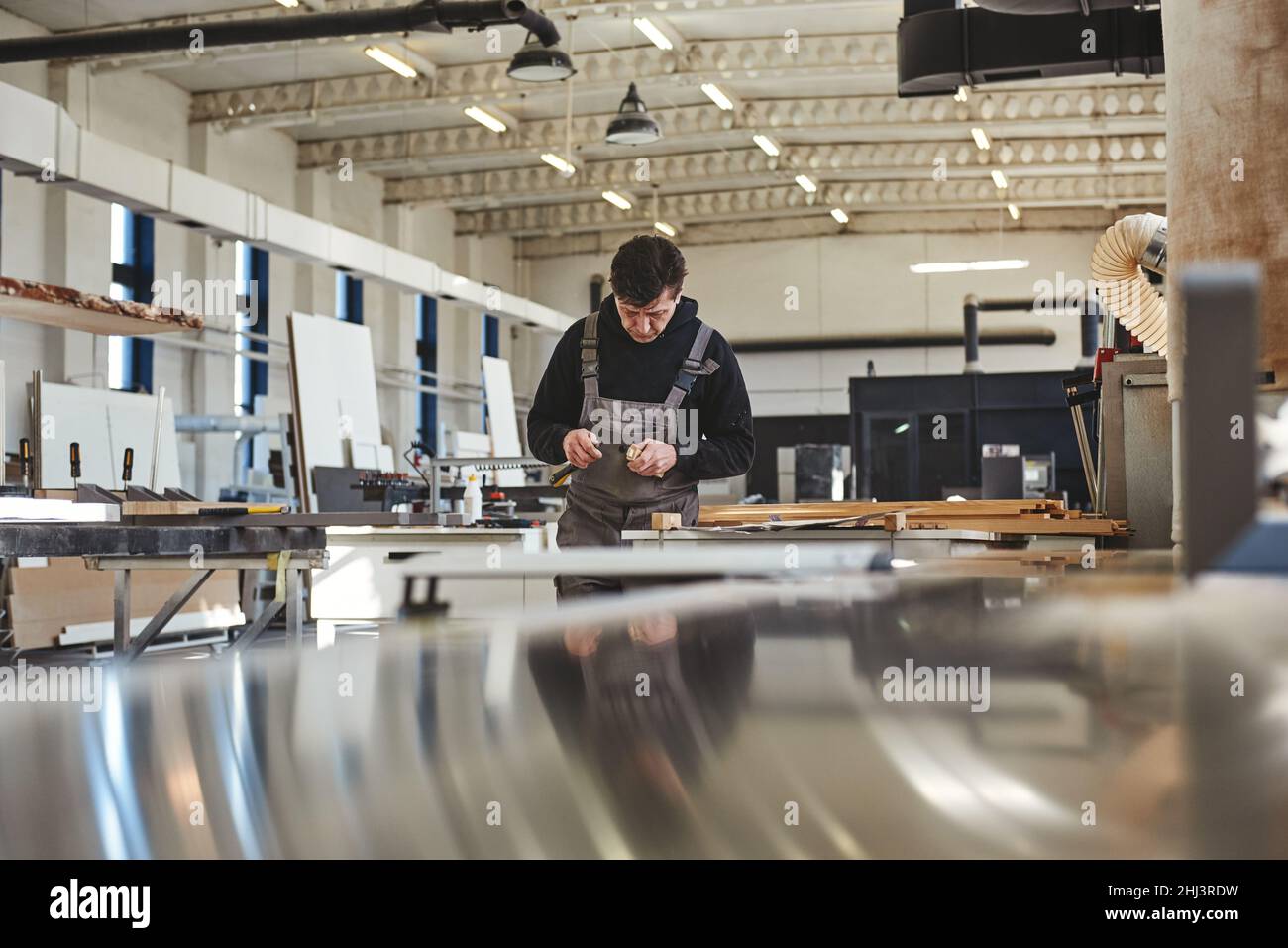 Professional carpenter at work, he is carving wood using a woodworking ...