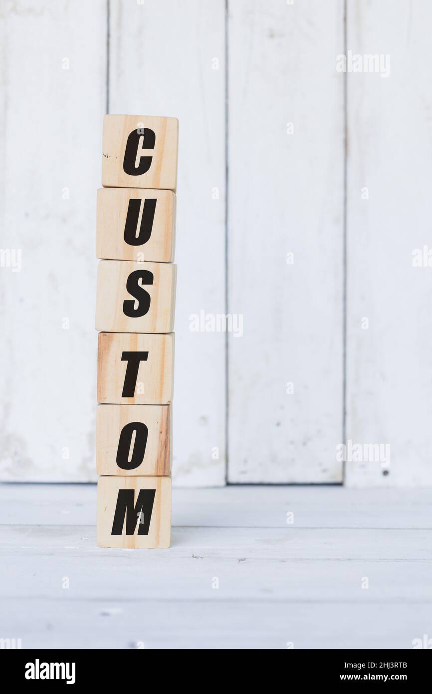wooden cube, with the word custom, with white wooden background Stock ...