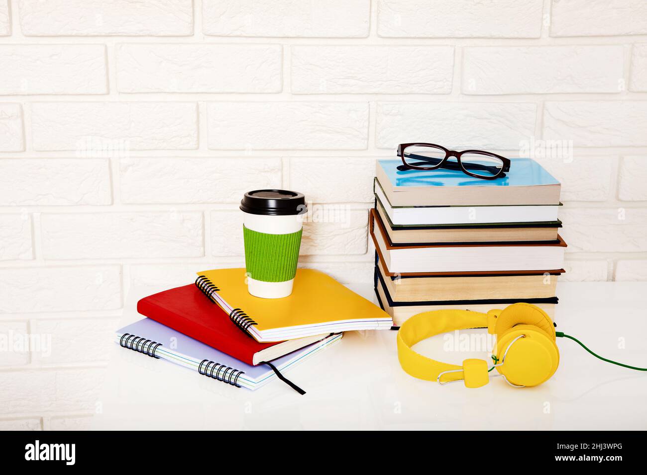 Workspace and education accessories on the table. Cup of coffee, books ...