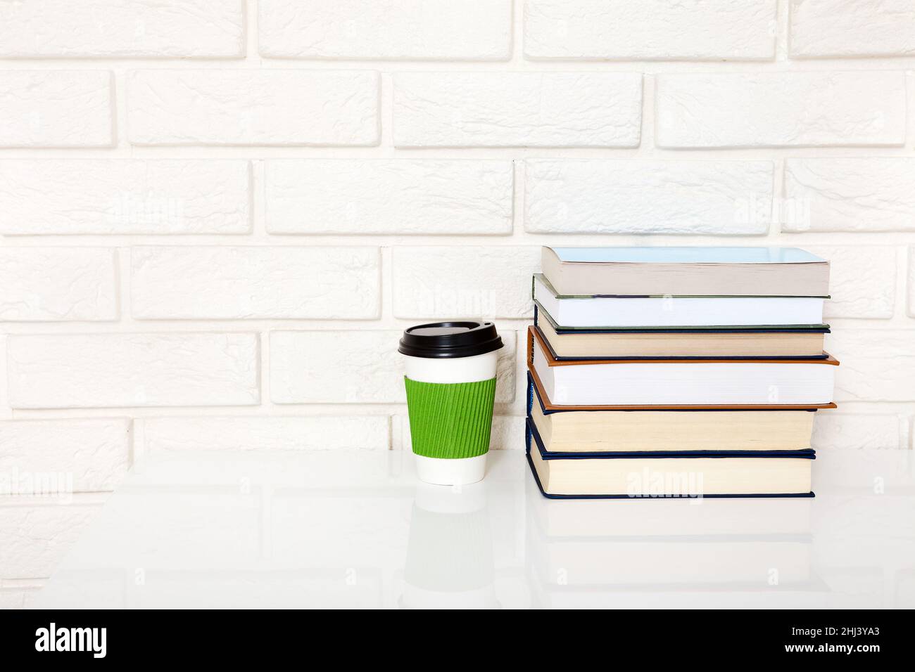 Education literature. Cup of coffee and books on the table in a class ...