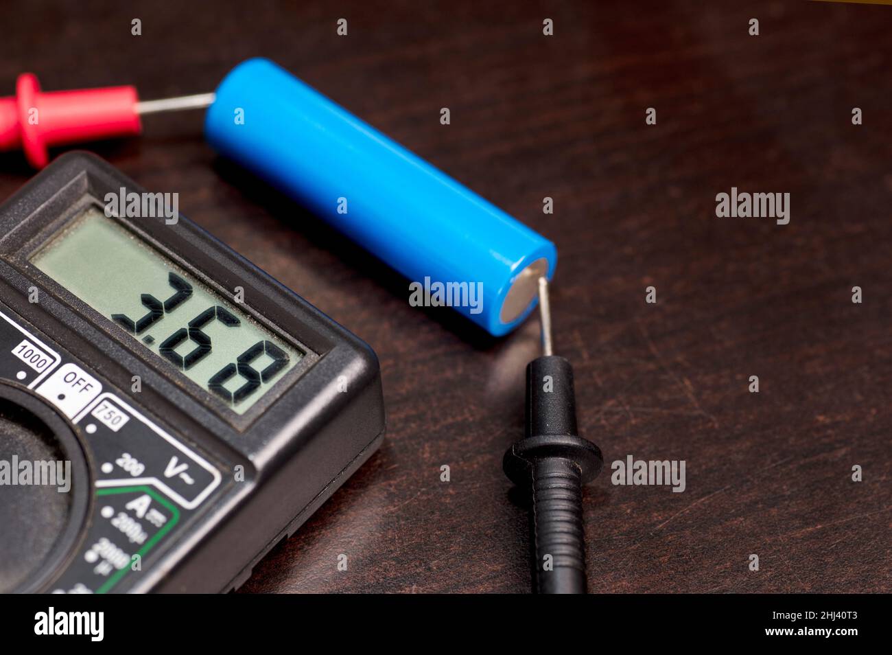 battery 18650 with multimeter, voltmeter in the hands of a man, red ...
