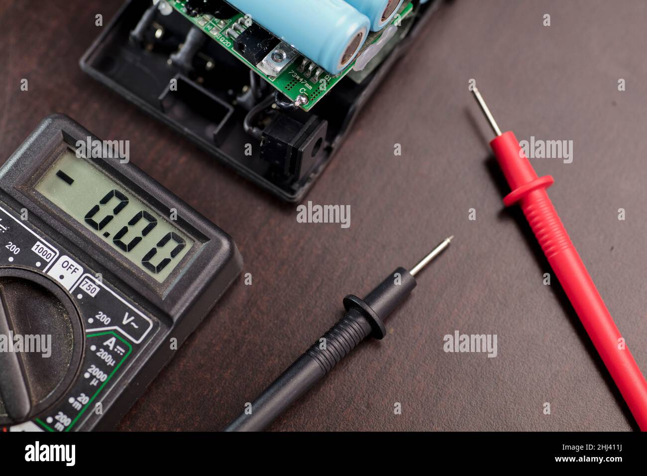 battery with multimeter, red positive pole, black negative pole, on ...