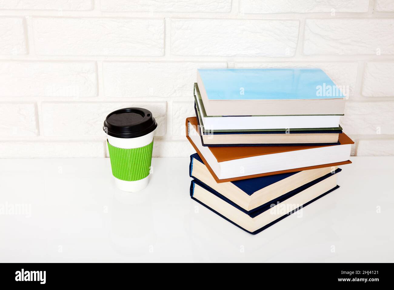 Education literature. Cup of coffee and books on the table in a class ...