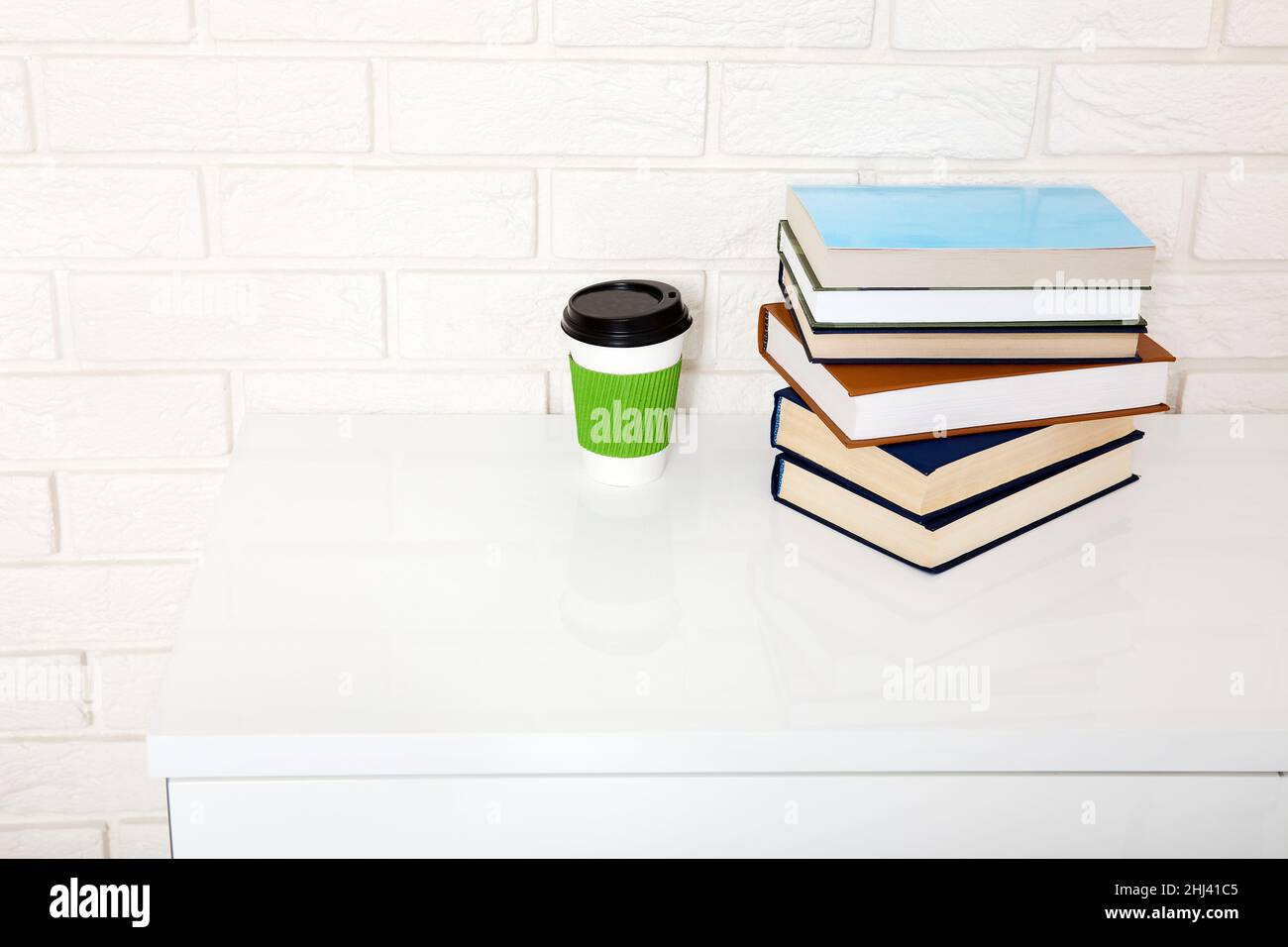 Education literature. Cup of coffee and books on the table in a class ...