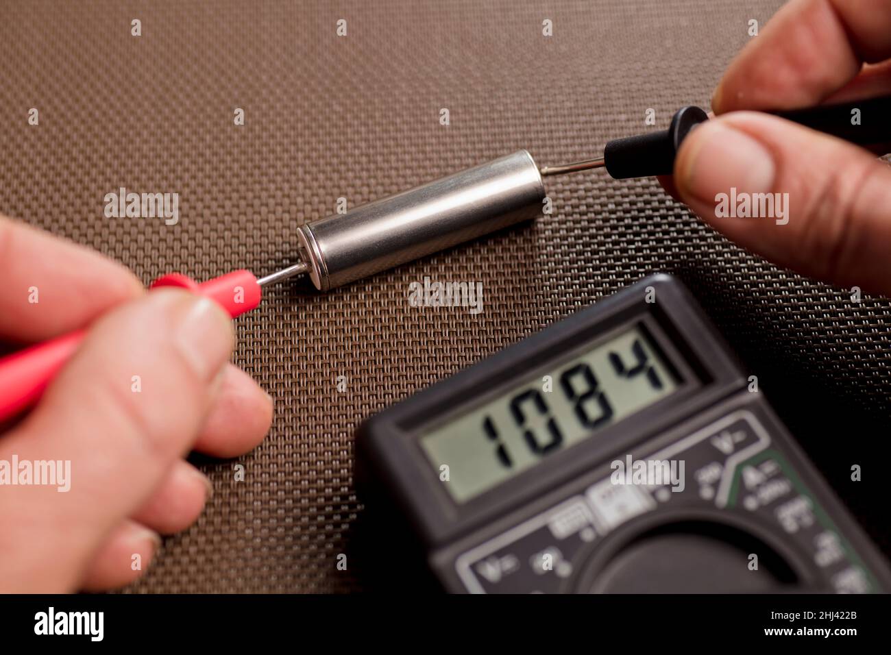 battery with multimeter, volt calculator, voltmeter in the hands of a ...