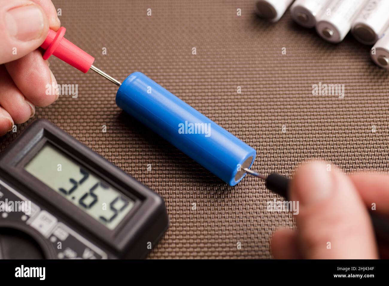 battery with multimeter,volt calculator, voltmeter in the hands of a ...