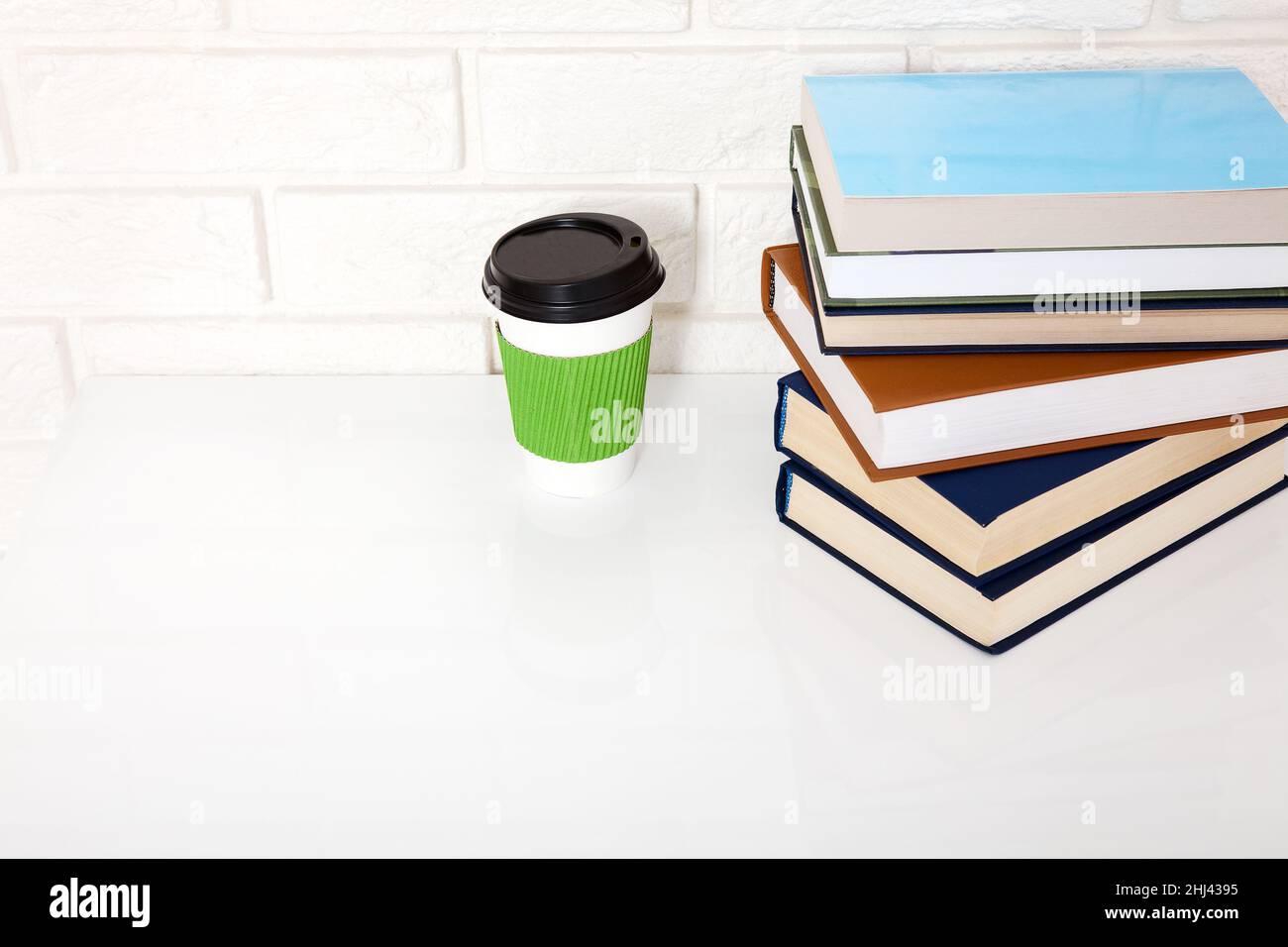 Education literature. Cup of coffee and books on the table in a class ...