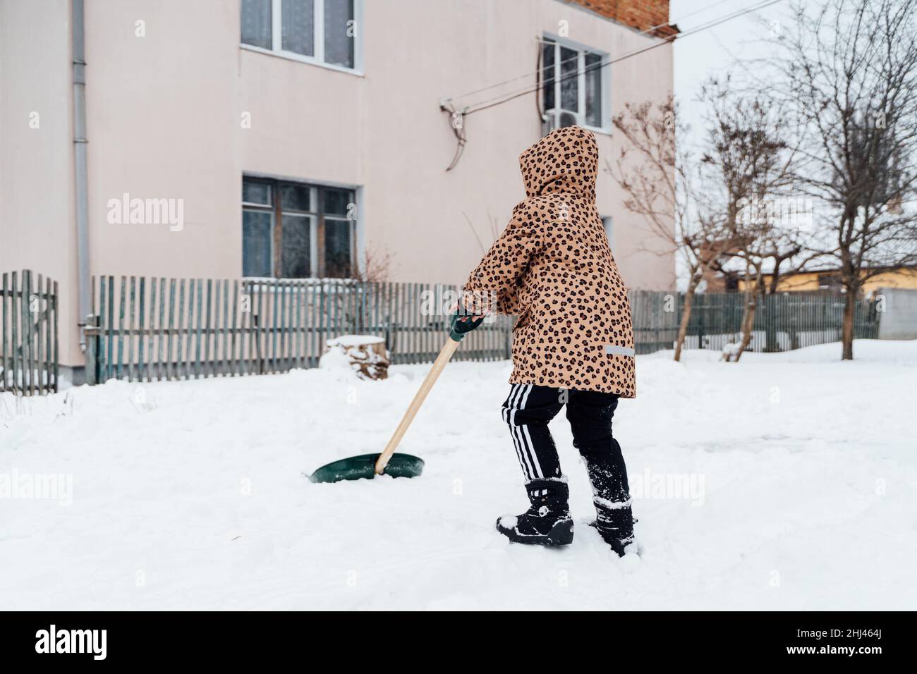 Low angle view of the little kid girl helping to clean pathway from ...
