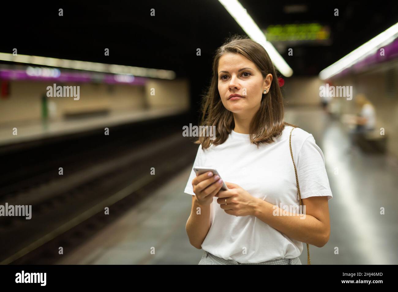 Female using mobile phone on station Stock Photo - Alamy