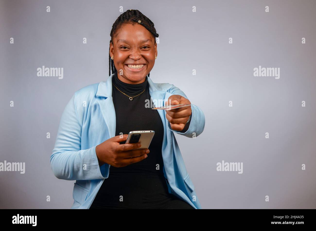 lady smiling operating her phone giving out her credit card Stock Photo ...