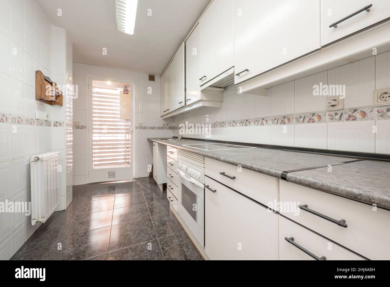 Conventional kitchen with white furniture, black handles and gray ...