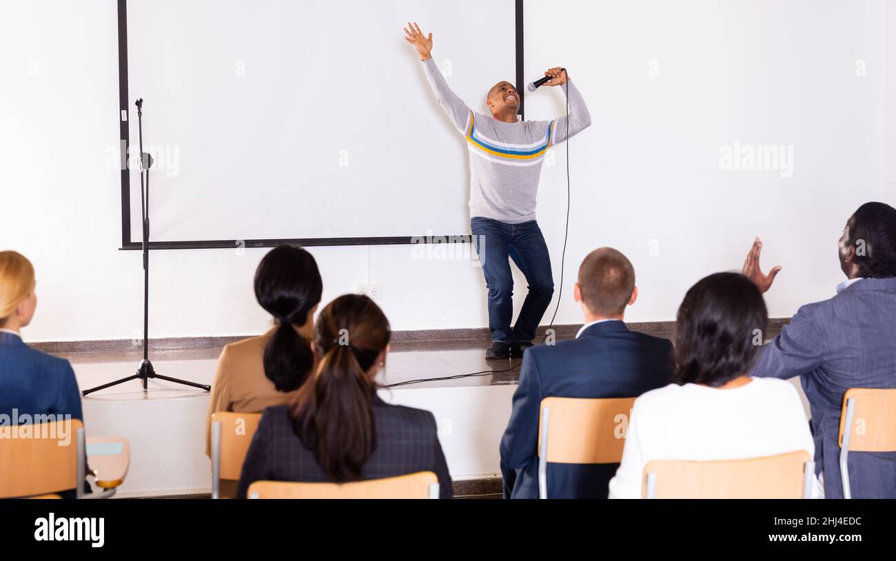 Male coach giving speech at conference hall Stock Photo - Alamy